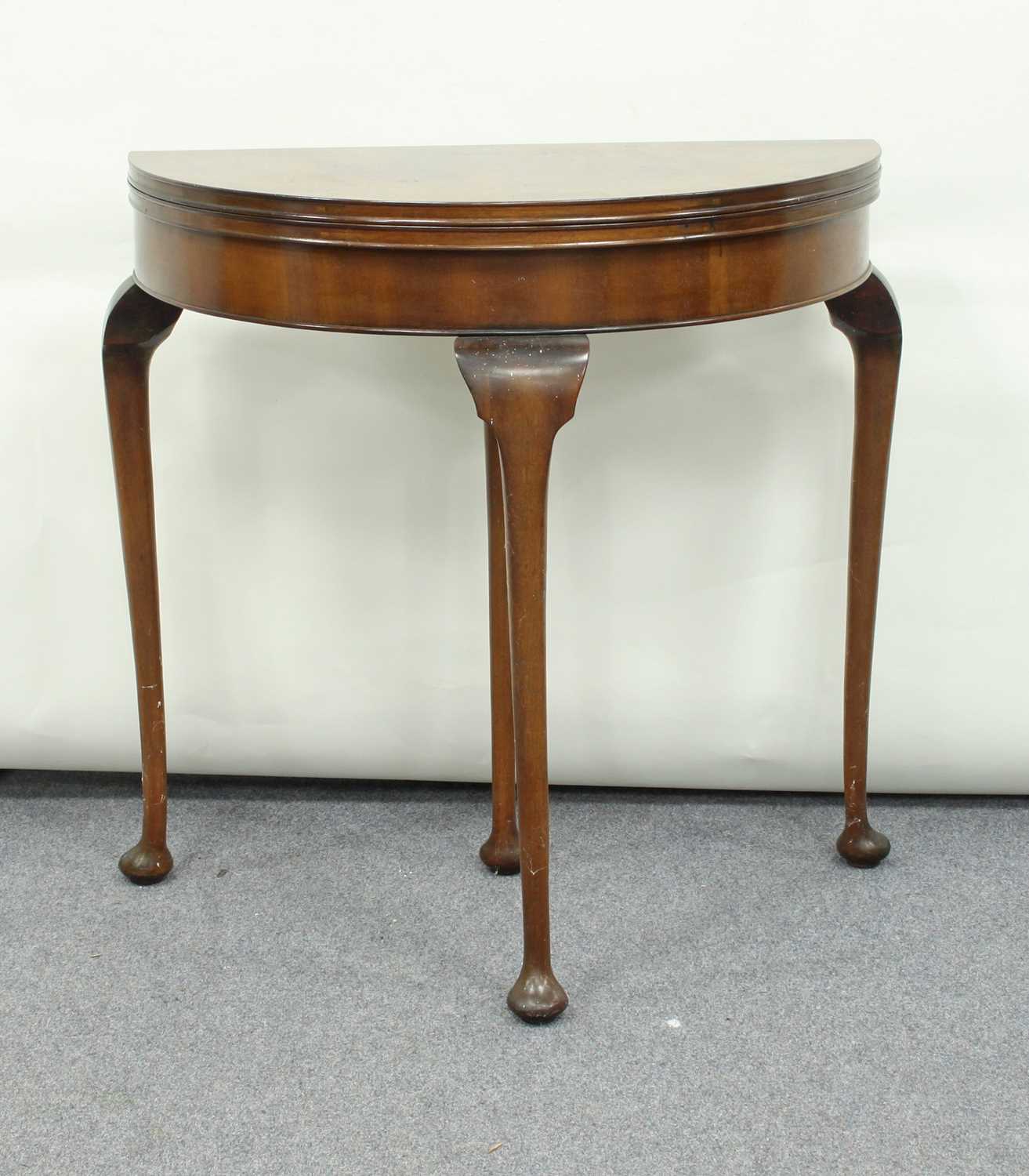 Lot 239 - A walnut half-round card table on cabriole