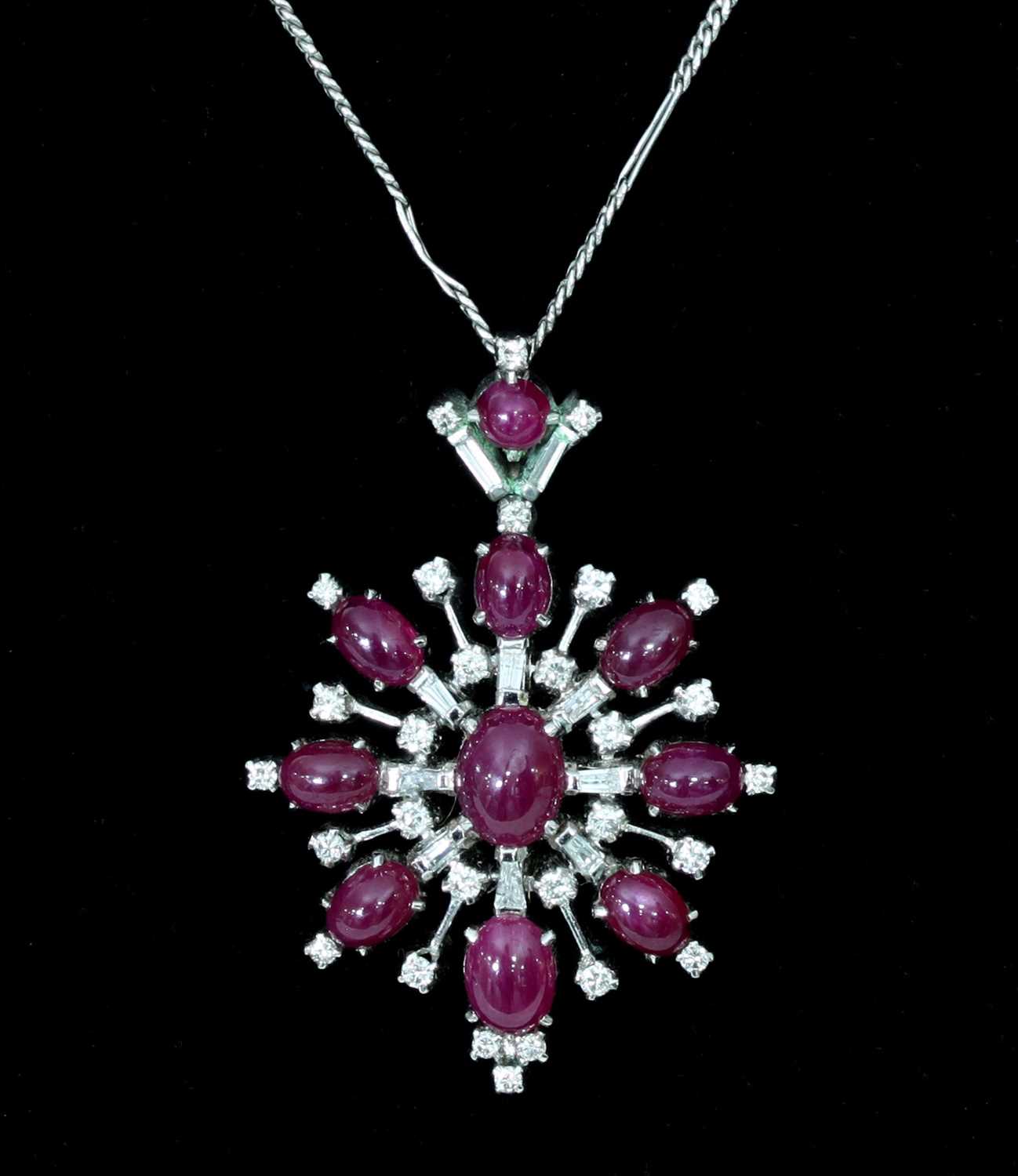 Lot 138 - A ruby and diamond pendant of starburst form,