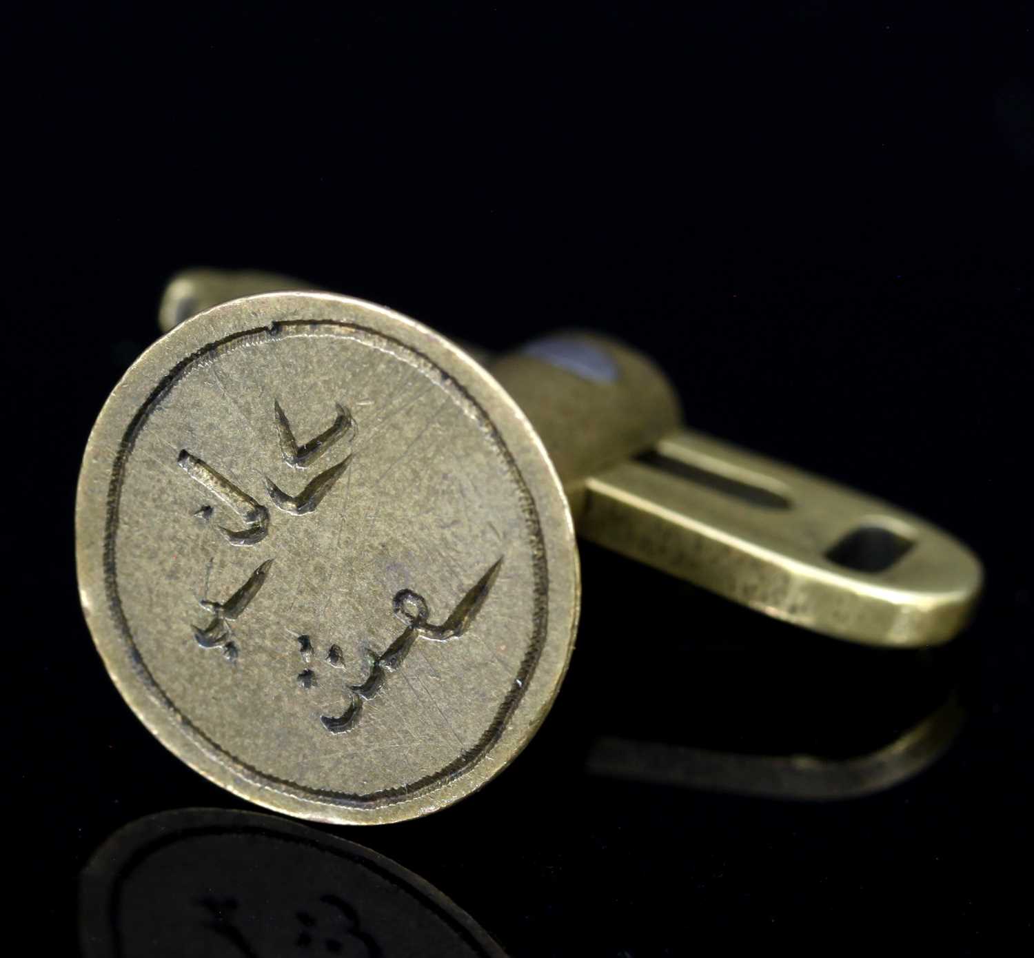 Lot 575 - A brass cloak clasp, inscribed in Arabic