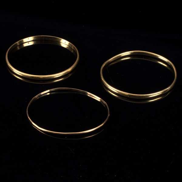 Lot 12 - Two 18ct yellow gold bangles and a 9ct bangle,