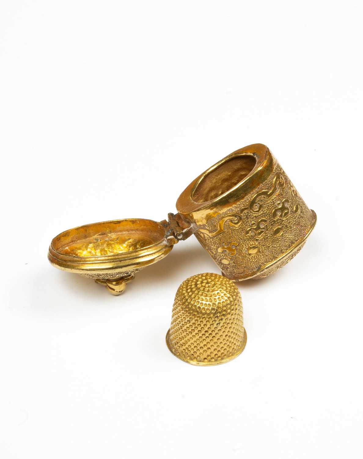 Lot 831 - A gilt metal thimble case and thimble for a