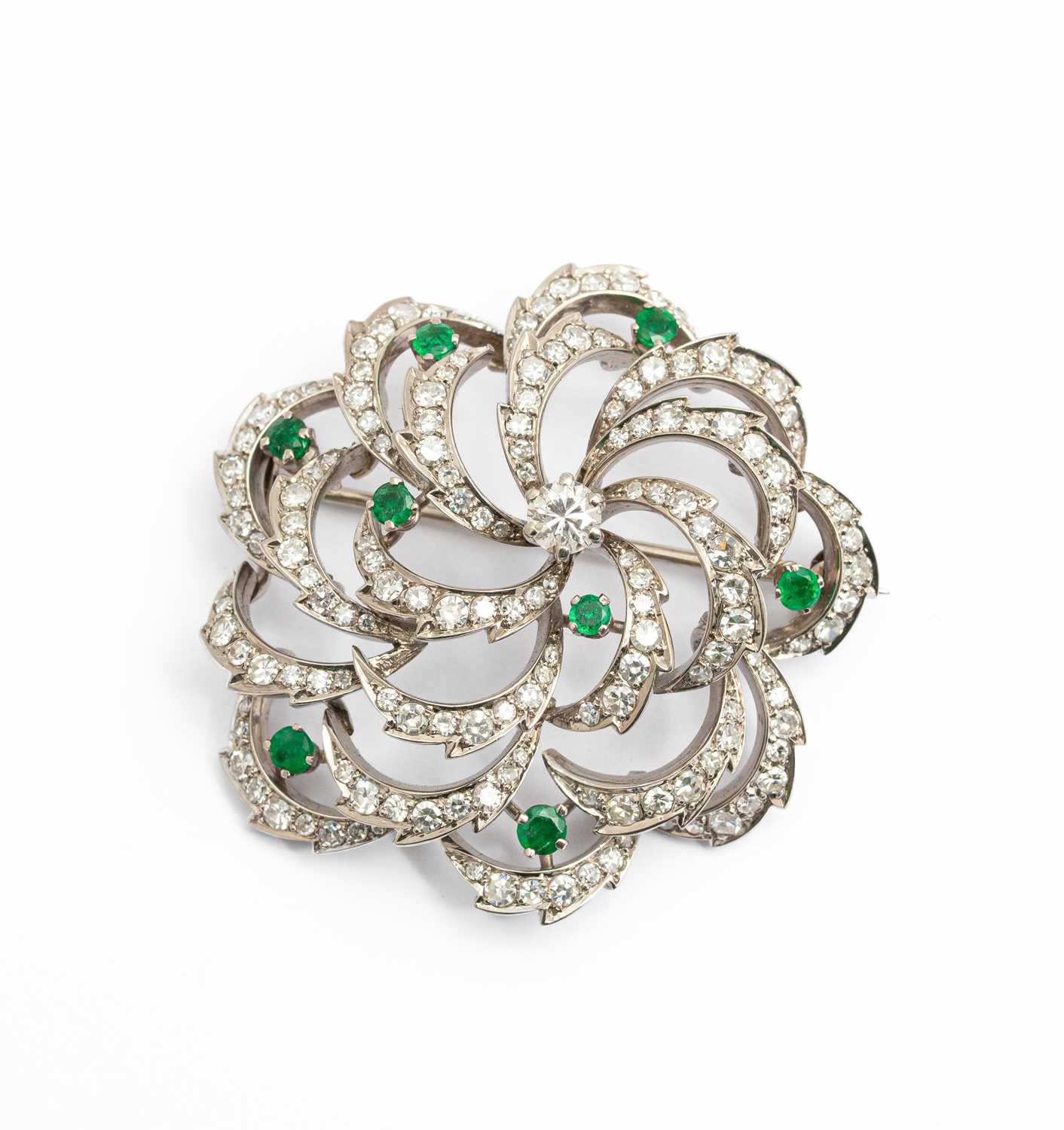 Lot 165 - A diamond and emerald circular floral brooch